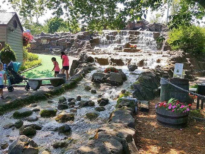 Water cascades over ancient-looking rocks, creating both a stunning backdrop and the perfect excuse for why your ball didn't go where intended.