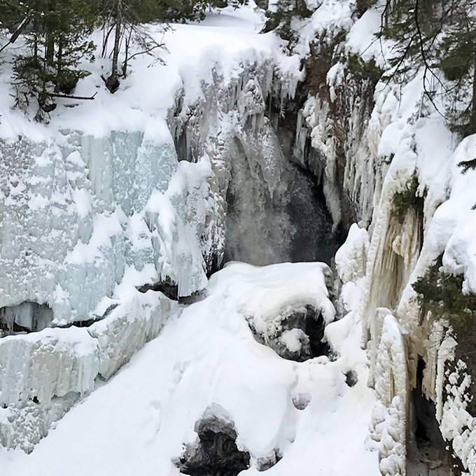 Winter transforms the falls into a frozen masterpiece that looks like Elsa from Frozen decided to vacation in Michigan.