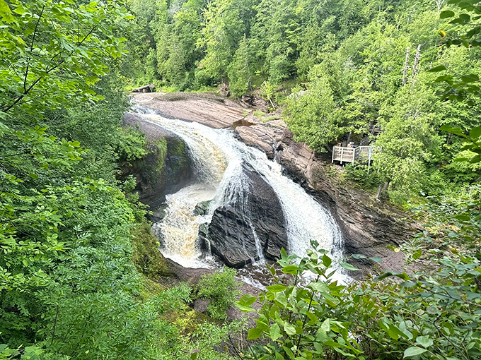 From above, the waterfall reveals its full dramatic character, cascading powerfully through ancient rock channels carved over countless millennia.