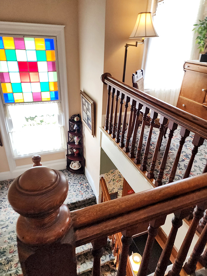 Sunlight streams through colorful stained glass, casting rainbow patterns on a staircase that's seen generations of footsteps.