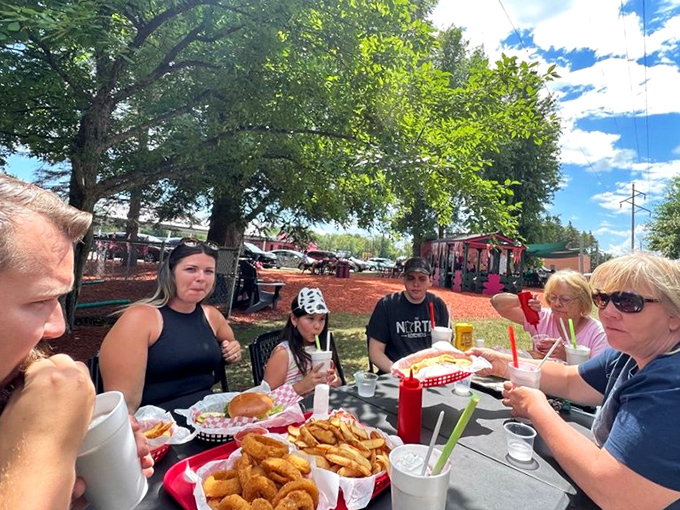 Happy families gather around picnic tables, creating memories between bites of burgers and stolen fries from each other's baskets.