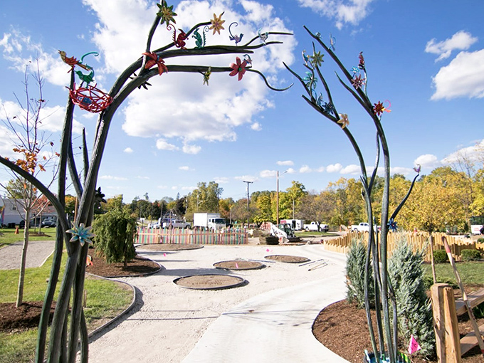 A whimsical metal archway adorned with flowers and stars welcomes visitors into this real-life storybook setting with artistic flair.
