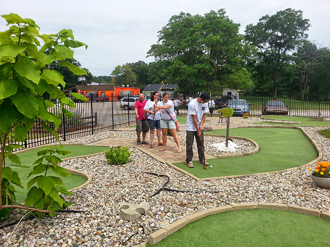 Golfers concentrate on their next shot while surrounded by quirky course features. In Hell's mini-golf, the challenge isn't avoiding flames but making par.
