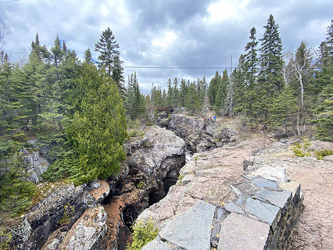 The earth splits open to reveal its geological secrets, with water carving pathways through rock over countless centuries.