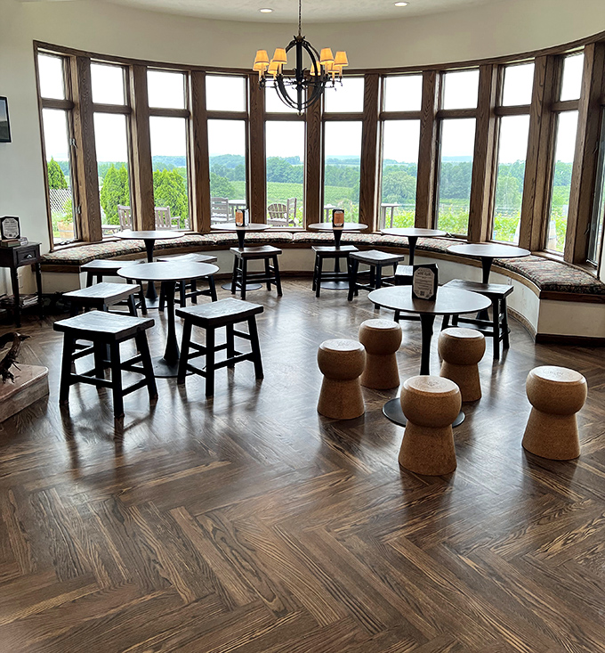 The circular tasting room offers 180-degree views of the vineyards and bay beyond, with cork stools adding whimsical touches to the elegant space.