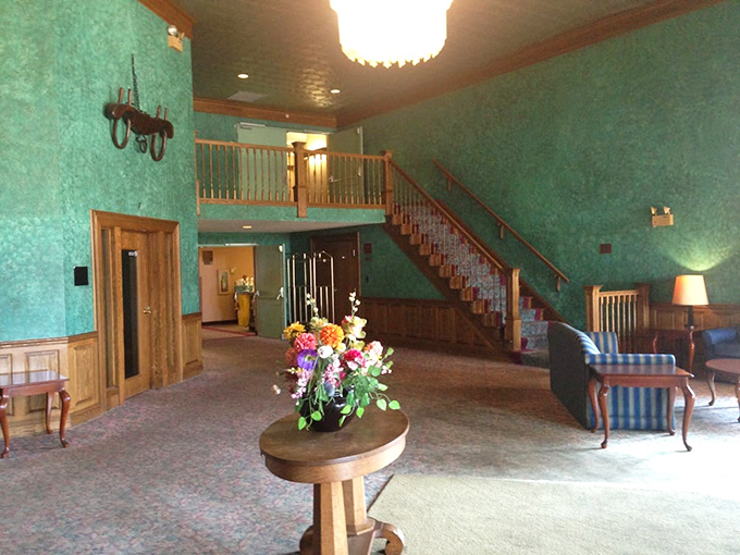 The interior lobby's turquoise walls and wooden staircase create a striking first impression that hints at the character-filled spaces throughout the hotel.