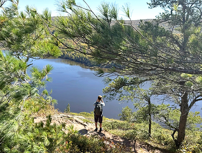 A solitary hiker pauses to drink in the vastness below &ndash; that moment when you realize you're just a speck in nature's grand design.