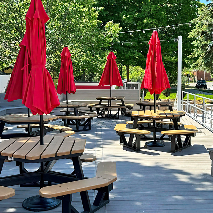 The outdoor deck with its cheerful red umbrellas creates the perfect stage for the summer ritual of ice cream enjoyment.
