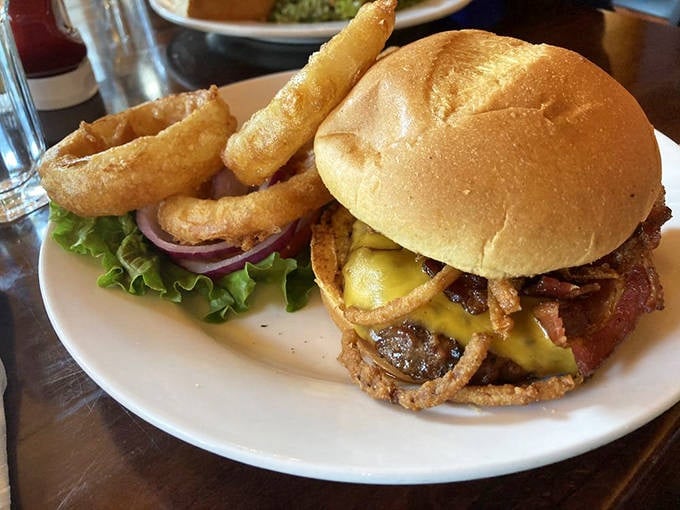 A burger that requires both hands and a strategy—topped with crispy onions that add the perfect crunch to each magnificent bite.