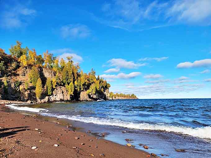 Agate Beach's rugged shoreline meets Lake Superior's crystal waters under a sky that seems impossibly blue.