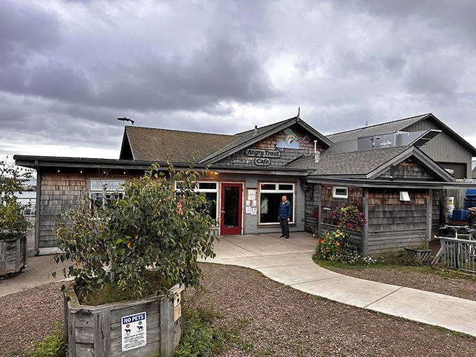 Rustic charm meets lakeside dining at the Angry Trout Cafe, where weathered cedar shingles and colorful flower boxes welcome hungry visitors.
