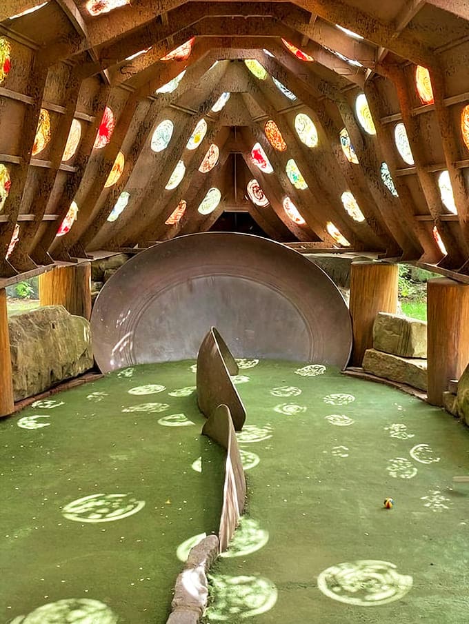 Step inside the "Holey Ship" where stained glass windows transform sunlight into a kaleidoscope of colors across this otherworldly putting green.