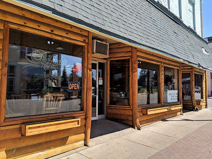 Bojack's rustic log cabin exterior welcomes visitors with warm wooden charm and large windows that promise cozy delights within.