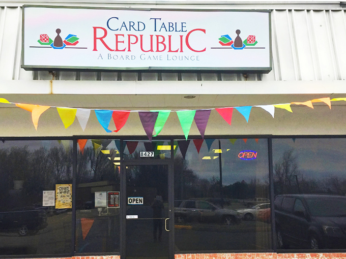 The welcoming facade of Card Table Republic beckons gamers with colorful pennants and the promise of analog adventures waiting inside.