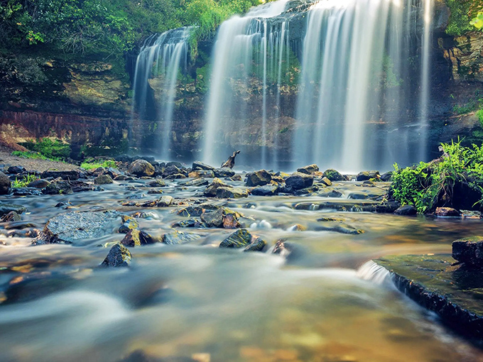Nature's masterpiece in motion: Cascade Falls creates a hypnotic curtain of water that seems to dance with the sunlight.