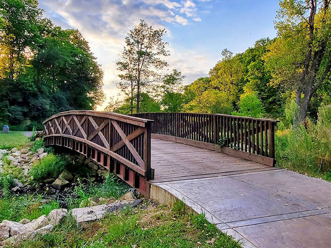 A rustic wooden bridge invites wanderers into Como Falls Park, where nature's symphony awaits just beyond the crossing.