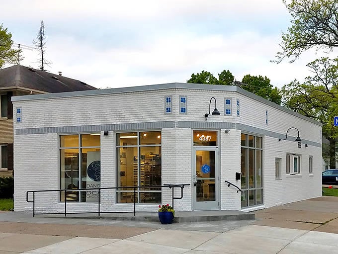 A pristine white brick corner shop that promises sweet adventures within &ndash; Dancing Bear Chocolate's inviting exterior beckons dessert lovers.