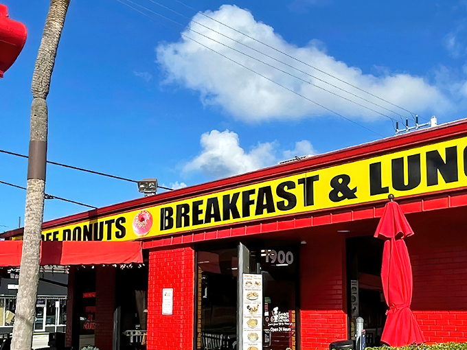 The vibrant red exterior of Dandee Donut Factory stands out like a beacon of breakfast hope against the Florida sky.