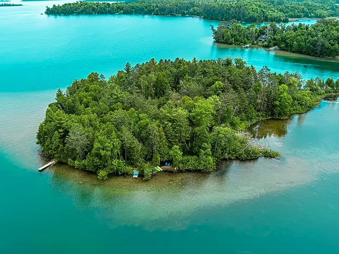 A bird's-eye view of paradise: Deer Lake's turquoise waters embrace a verdant island, nature's perfect hideaway in Minnesota's northern wilderness.