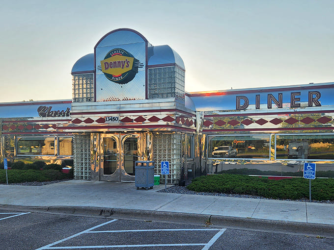 The gleaming chrome and glass block exterior of Denny's Classic Diner shines like a time-traveling beacon in Burnsville, Minnesota, especially beautiful at sunset.