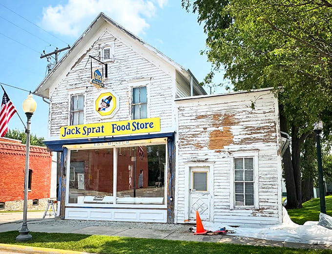 The weathered white clapboard exterior of Jack Sprat Food Store stands as a time portal, its yellow sign a beacon to curious travelers.