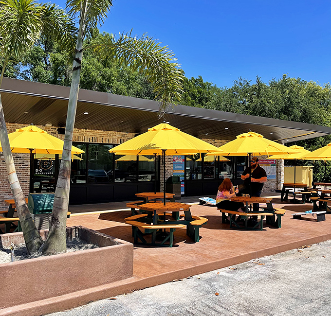 Sunshine and sweet treats await at DG Doughnuts' inviting outdoor patio, where bright yellow umbrellas create the perfect spot for doughnut diplomacy.