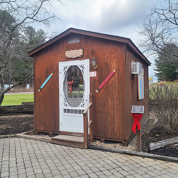 The charming wooden cabin with its distinctive white door beckons visitors into a world where pencil sharpeners become treasured artifacts.