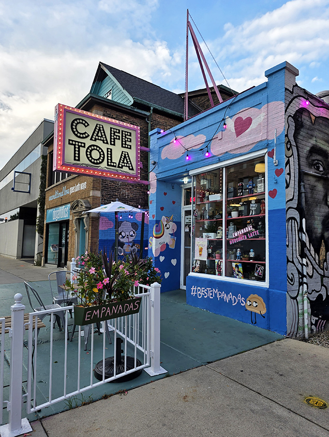 A vibrant blue storefront with a marquee sign that screams "food paradise" &ndash; Cafe Tola's exterior is as inviting as a warm hug.