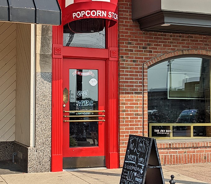 The iconic red doorway of The Little Popcorn Store stands like a portal to sweetness on Wheaton's Front Street, beckoning candy lovers of all ages.