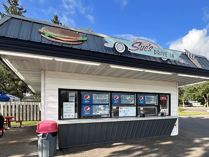 Sue's Drive-In storefront beckons with its classic Americana charm and promise of delicious treats waiting just beyond those service windows. 