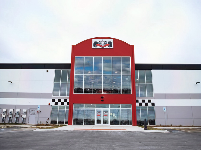 The striking red facade of Accelerate Indoor Speedway stands ready to welcome speed enthusiasts, its checkered flag motif promising adrenaline-pumping adventures inside.