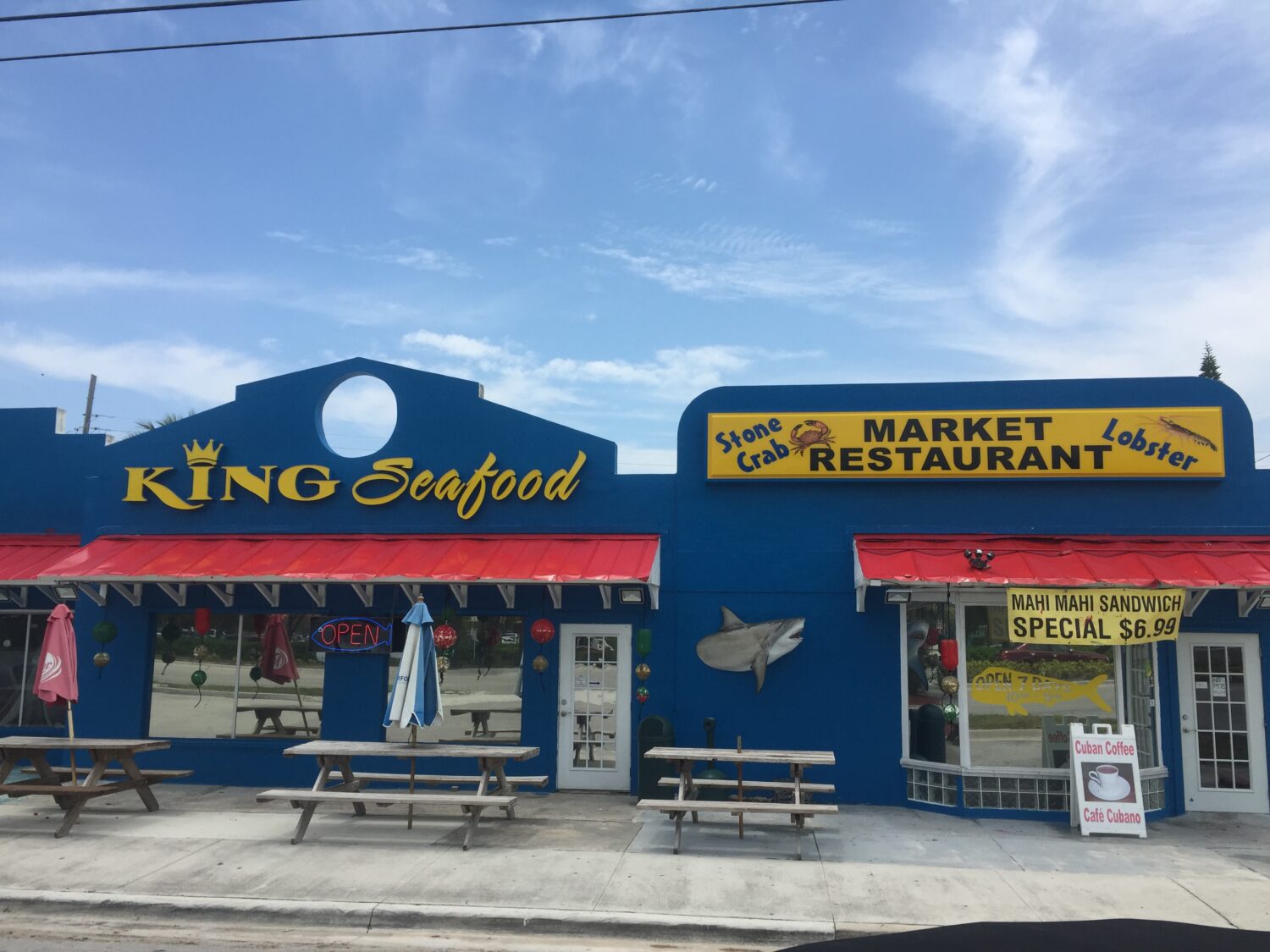 The vibrant blue facade of King Seafood stands out like a sapphire against Marathon's sky, promising oceanic treasures within.