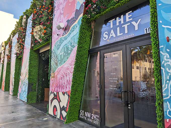 The Salty Donut's exterior bursts with Miami energy &ndash; vibrant murals and lush green walls create a storefront that's as artistic as the neighborhood it calls home.