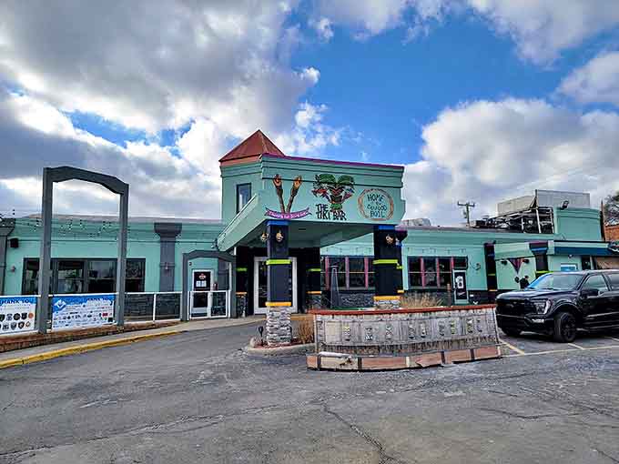 The mint-green exterior of The Beach Tiki Bar & Boil stands like a tropical mirage in Michigan, its distinctive copper-topped tower beckoning hungry travelers.