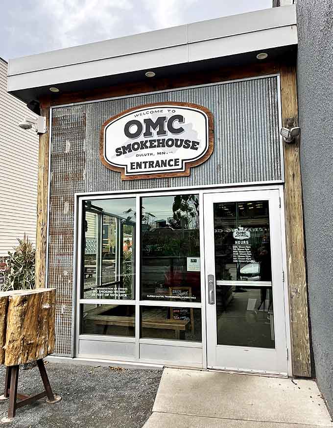 The unassuming entrance to OMC Smokehouse beckons with its industrial-chic vibe and promise of smoky delights within.