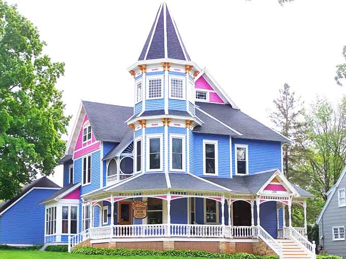 Victorian splendor in vibrant blue &ndash; this architectural confection stands proudly against the Minnesota sky, its tower reaching toward clouds that have witnessed a century of stories.