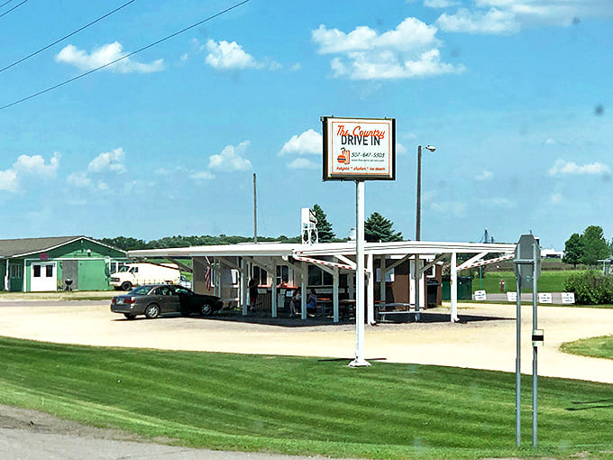 The Country Drive In stands proudly against the Minnesota sky, its vintage sign beckoning hungry travelers like a beacon of deliciousness.