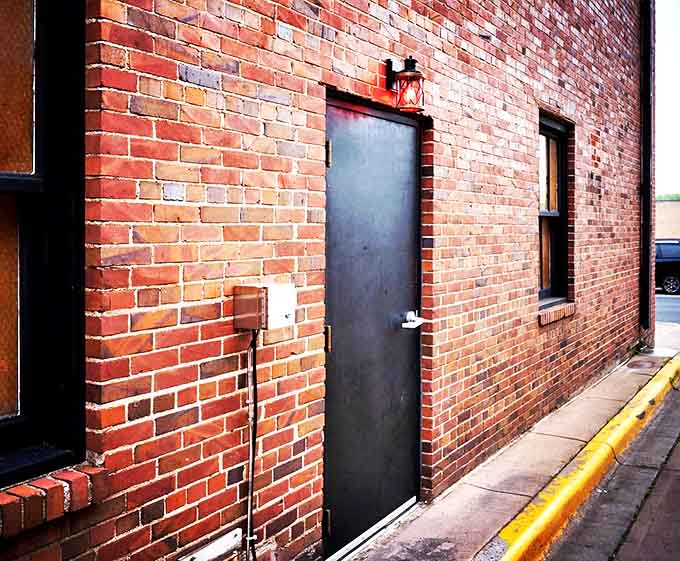 The unassuming black door with a red lantern &ndash; Prohibition's modern gateway stands quietly against weathered brick, beckoning only to those curious enough to discover its secrets.