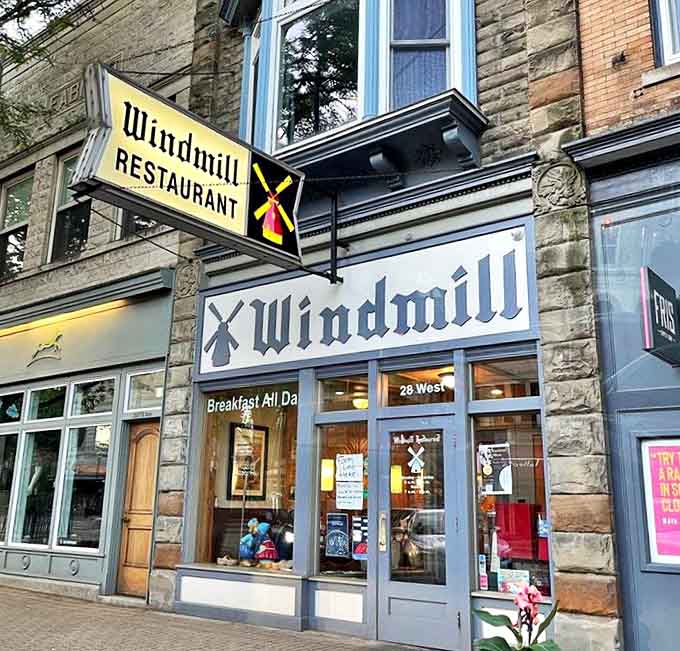 The iconic Windmill Restaurant sign beckons hungry travelers like a lighthouse for breakfast lovers, promising Dutch charm and morning delights in downtown Holland.