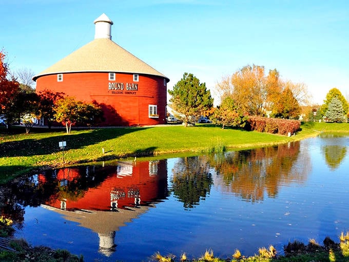 The iconic red Round Barn reflects perfectly in the adjacent pond, creating a double dose of rural charm that stops first-time visitors in their tracks.