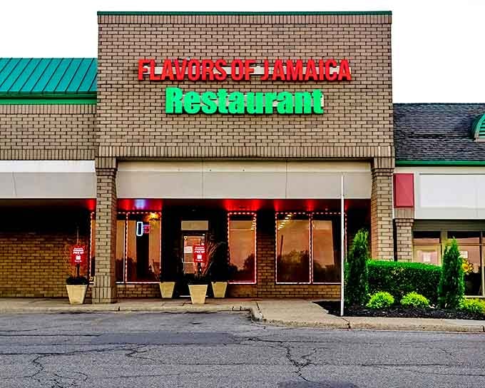 The vibrant red and green signage of Flavors of Jamaica stands out like a tropical beacon in Pontiac's suburban landscape.