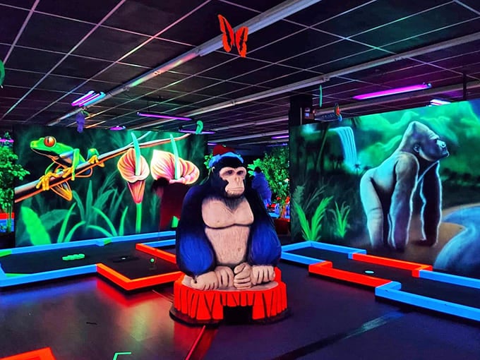 Glow Putt's entrance welcomes visitors with a vibrant jungle-themed archway, where colorful creatures seem to invite you into their neon realm.