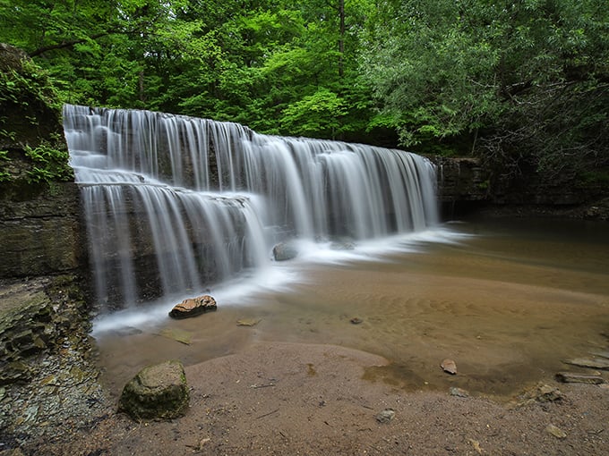 Hidden Falls cascades with hypnotic rhythm, nature's own meditation app set against a backdrop of emerald green tranquility.