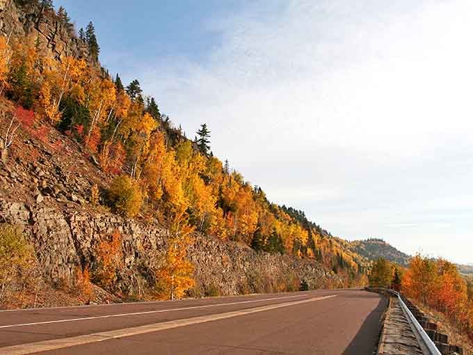 Highway 61 winds along Lake Superior's edge, where autumn paints the hillsides in a palette that would make Bob Ross weep with joy.