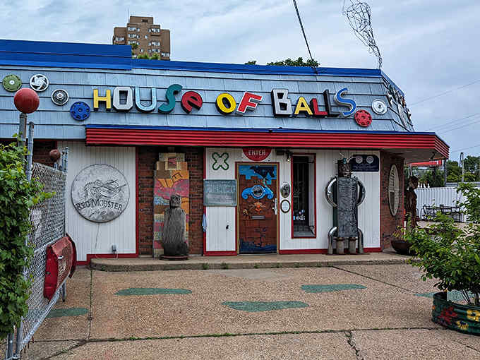 The colorful, quirky facade of House of Balls welcomes visitors with its playful signage and green footprints leading to a world of artistic wonder.