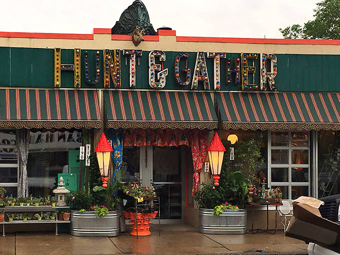 The iconic green storefront of Hunt & Gather beckons with carnival-style lettering and red lanterns, promising treasures that defy ordinary antique shopping experiences.