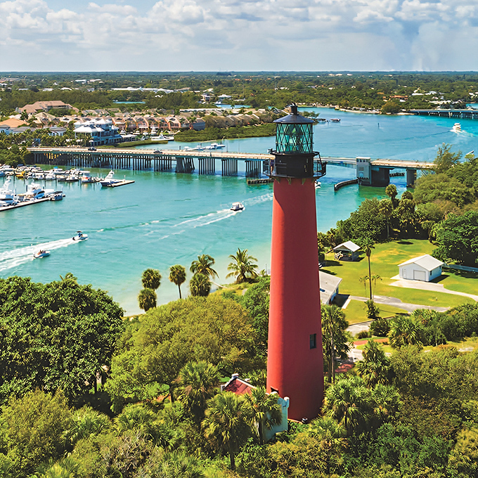 The crimson sentinel stands tall against Florida's azure sky, a 160-year-old maritime guardian still showing ships the way home.