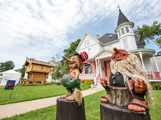 The Trollway welcomes visitors with whimsical wooden guardians, their mischievous grins suggesting they know secrets about Mount Horeb you're about to discover.
