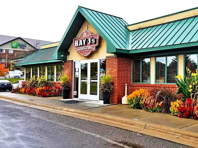 Ray J's welcoming exterior beckons with its distinctive green roof and seasonal flower displays &ndash; Minnesota hospitality at first glance.