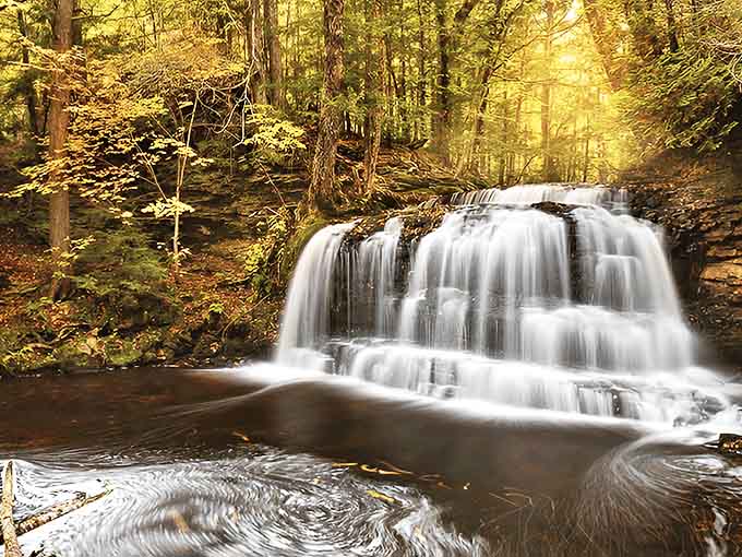 Nature's masterpiece in motion: Rock River Falls cascades through golden autumn light, creating a scene that makes even smartphone photographers look like professionals.